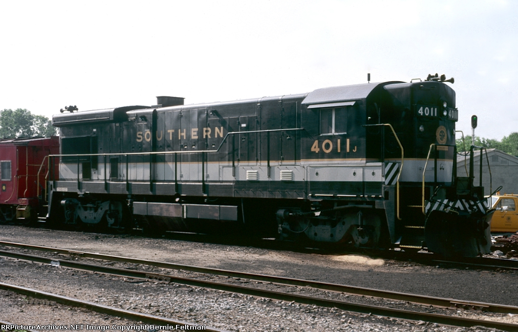 Southern Railway B23-7 #4011, coupled to its "yellow belly" local freight caboose, rests between ...